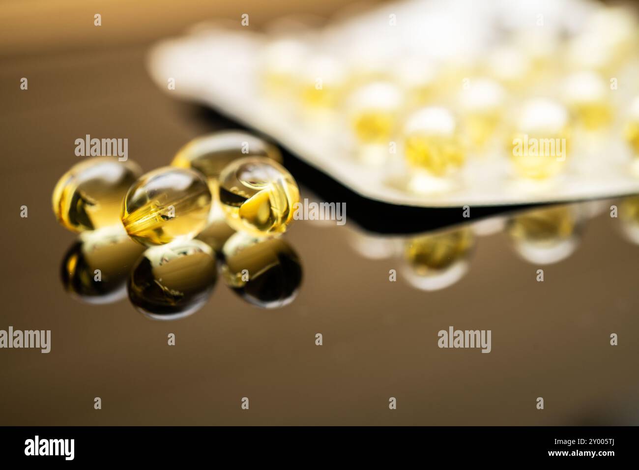 Yellow transparent capsules of vitamin D and fish oil omega-3 ...