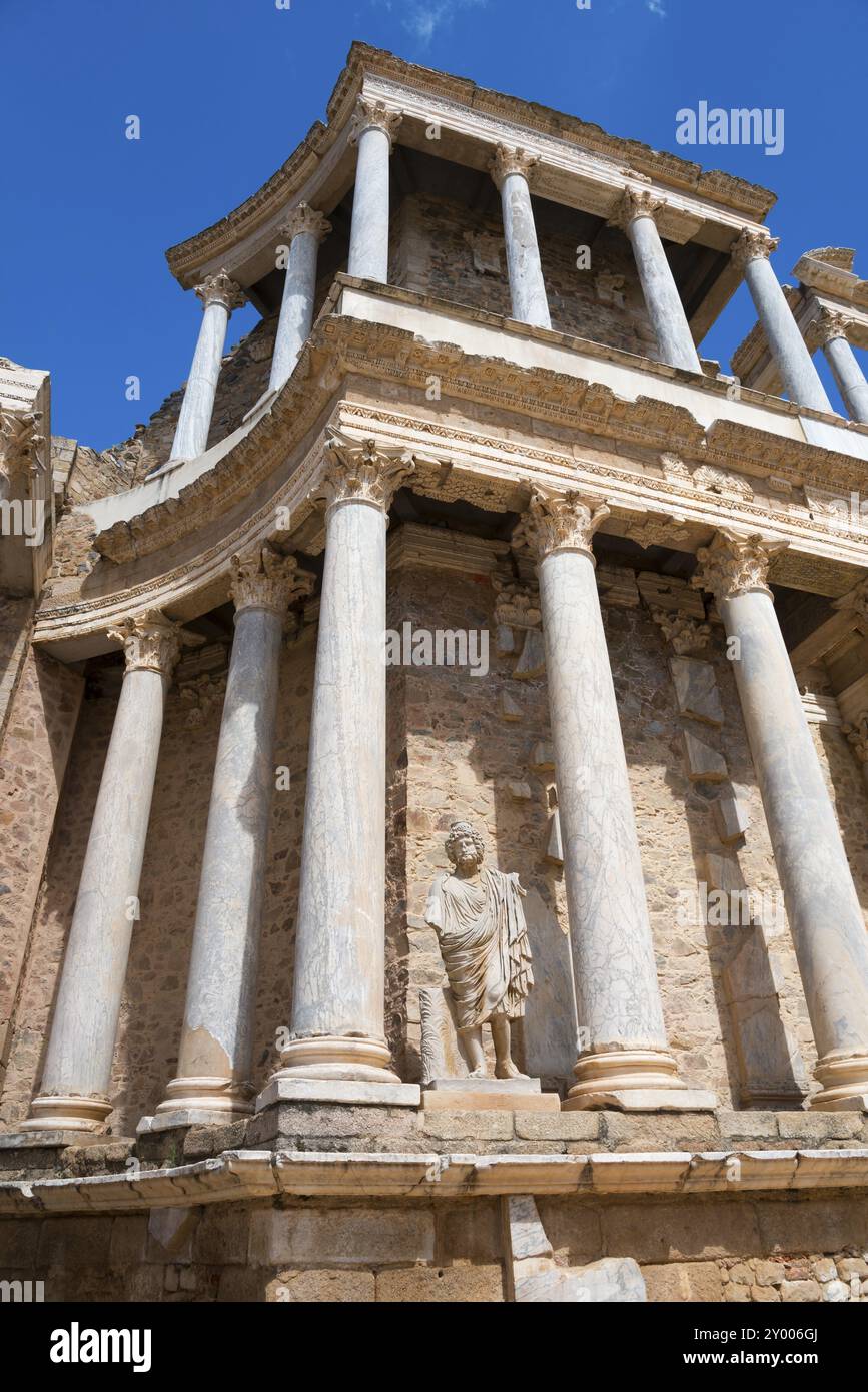 Close-up of a statue in front of ancient columns and stone walls, an ...