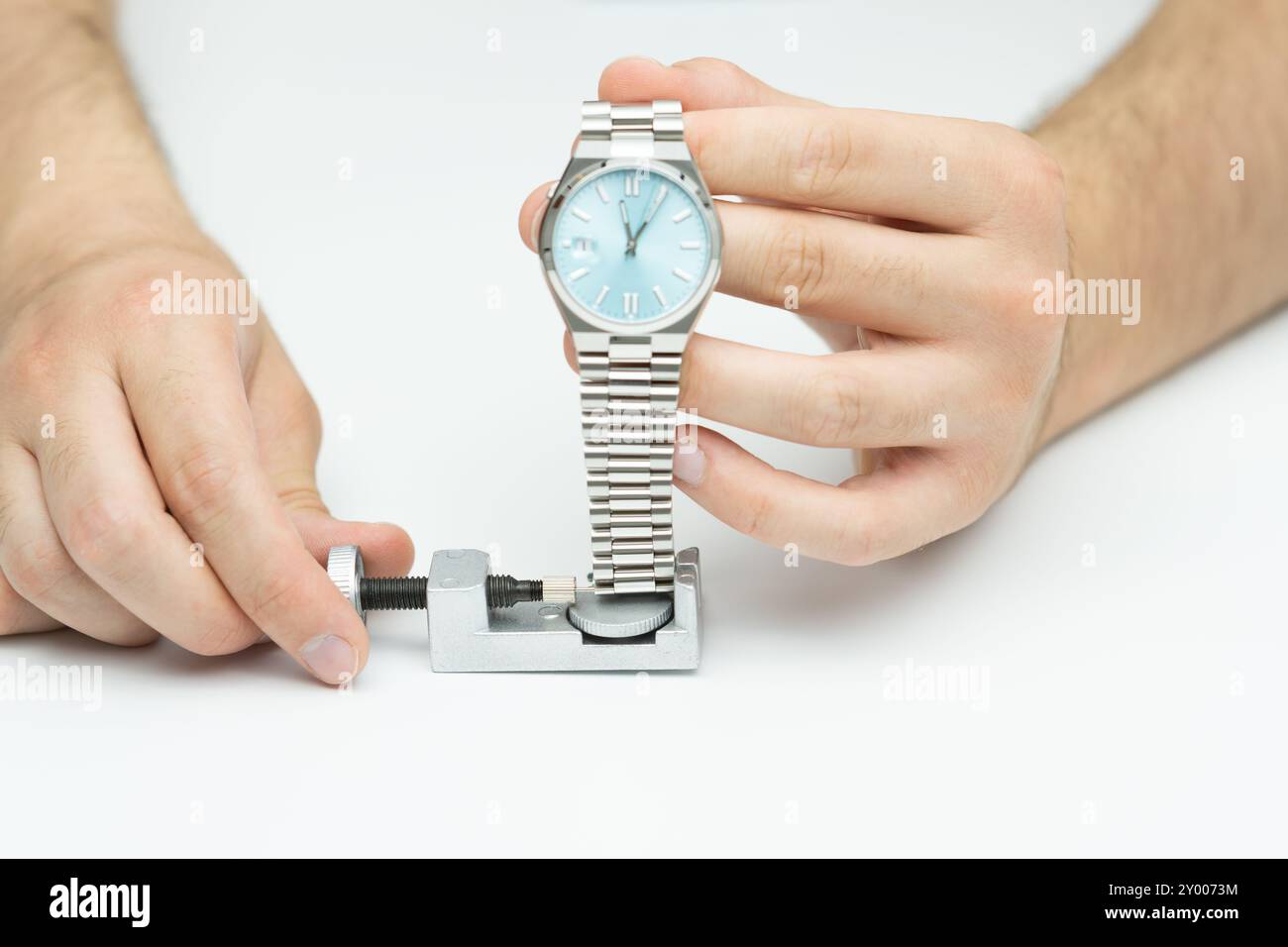 Adjusting watch strap with link remover tool Stock Photo - Alamy