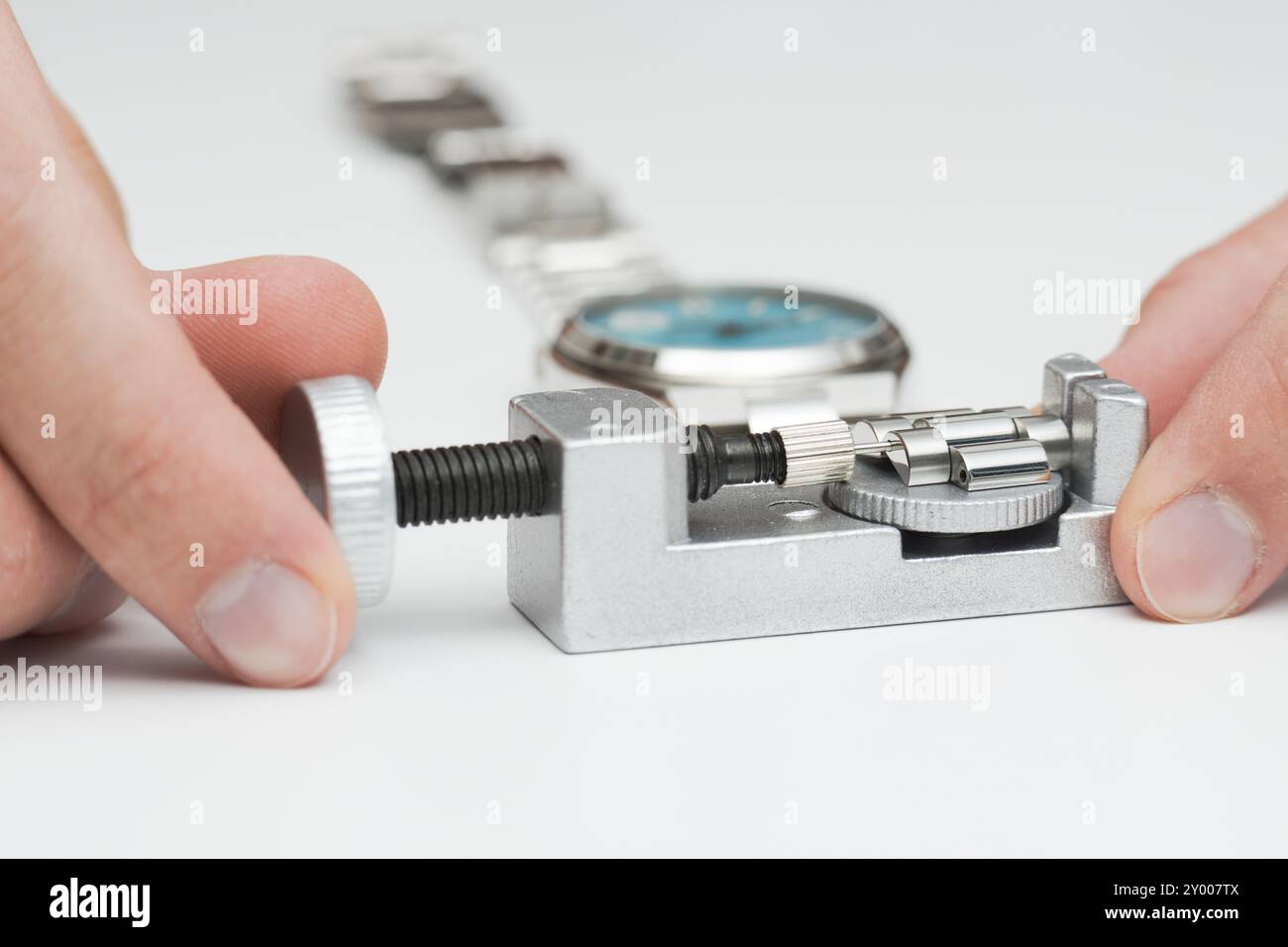 Adjusting watch strap with link remover tool Stock Photo - Alamy