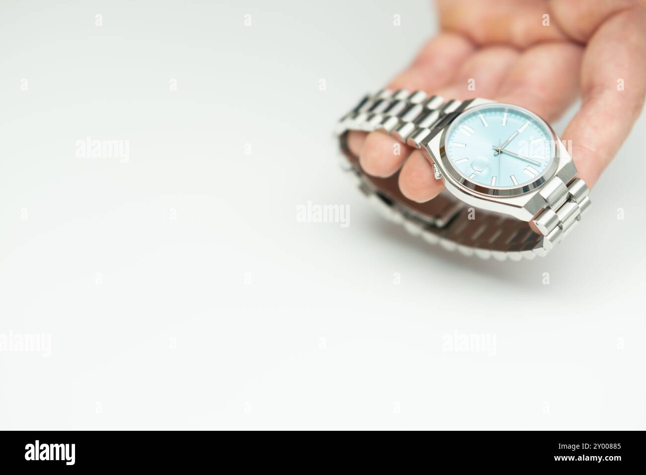 Male hand holding modern luxury silver tiffany blue watch on white ...
