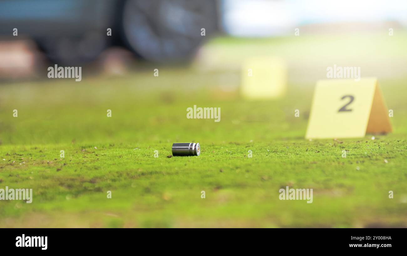 Spent bullet casing lying on the ground with blur number 2 sign ...