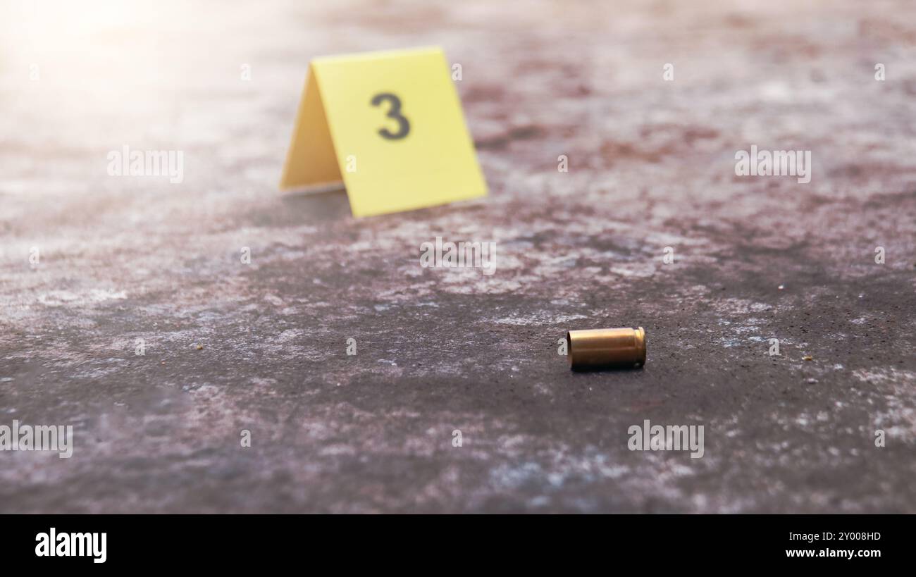 Spent bullet casing lying on the ground with blur number 3 sign ...
