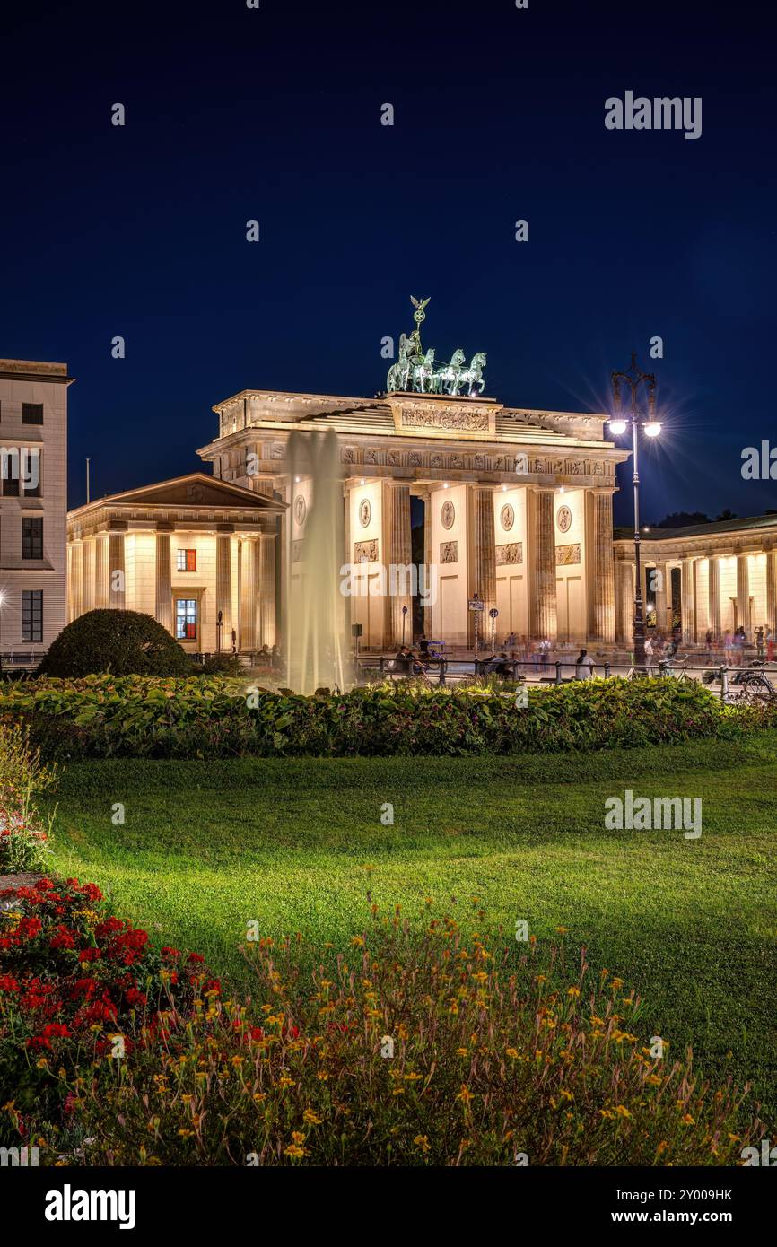 The illuminated Brandenburg Gate in Berlin with a water fountain at ...