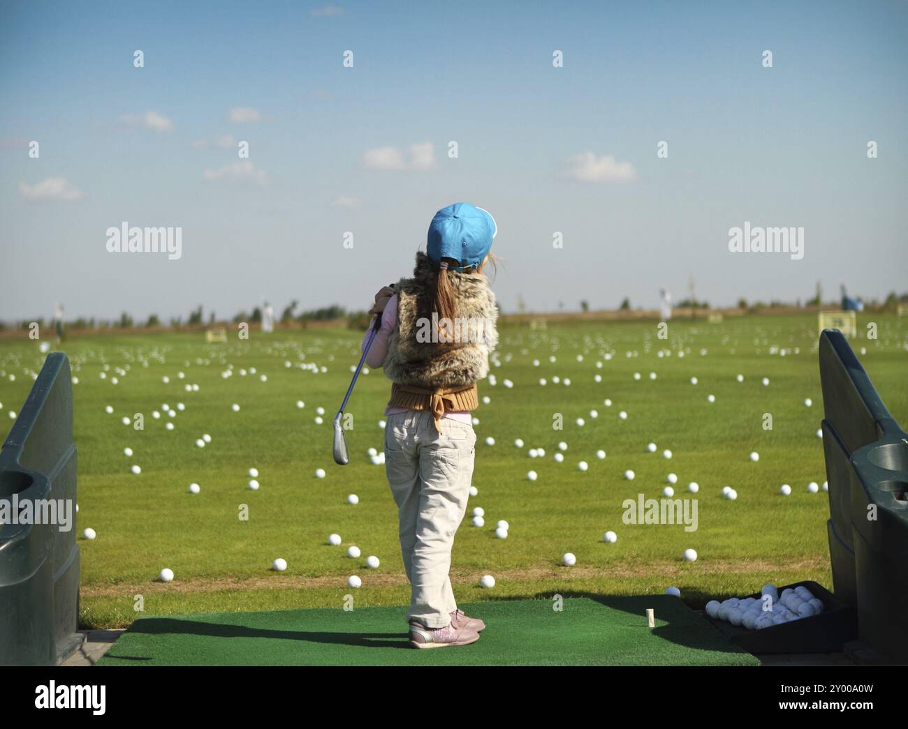 Little girl swinging golf club, rear view Stock Photo - Alamy