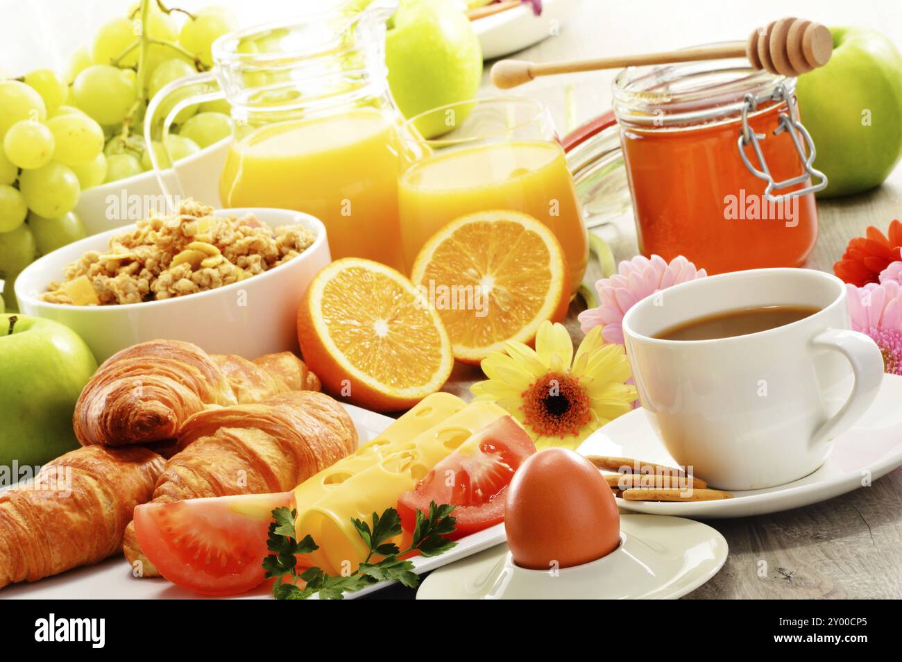 Breakfast consisting of fruits, orange juice, coffee, honey, bread and ...