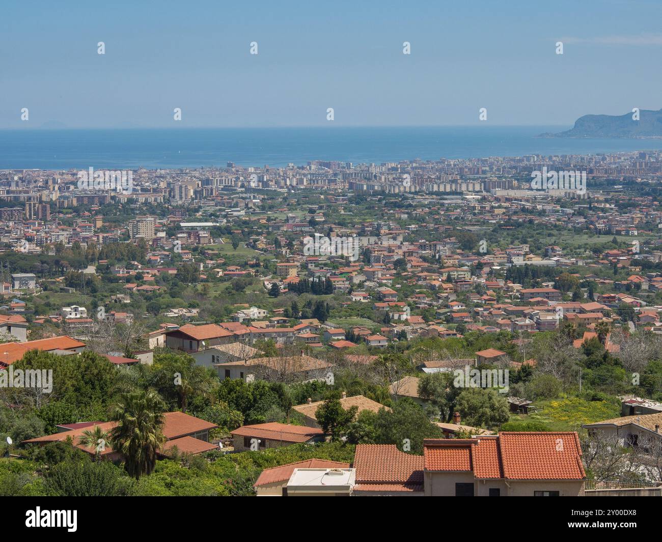 City that stretches over hills to the sea with red roofs and green ...