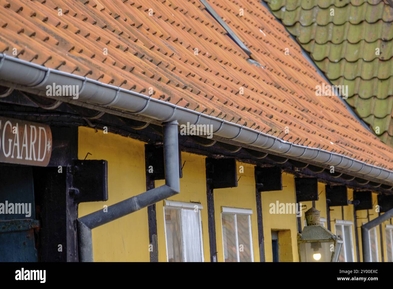 Engaged roofs and windows of a half-timbered house with yellow walls ...