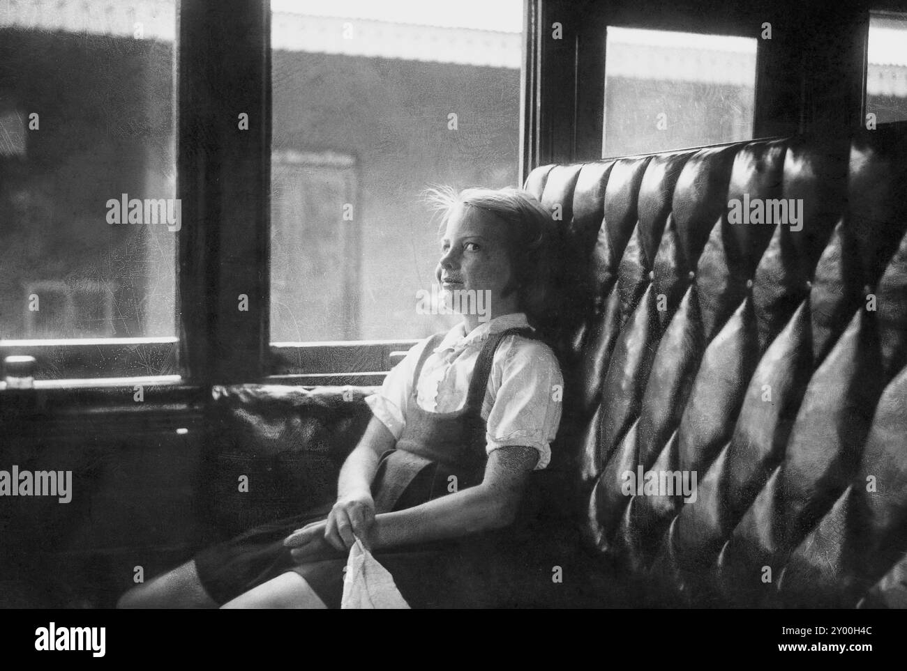 1950s, historical, a young girl sitting on the high leather seat in the ...