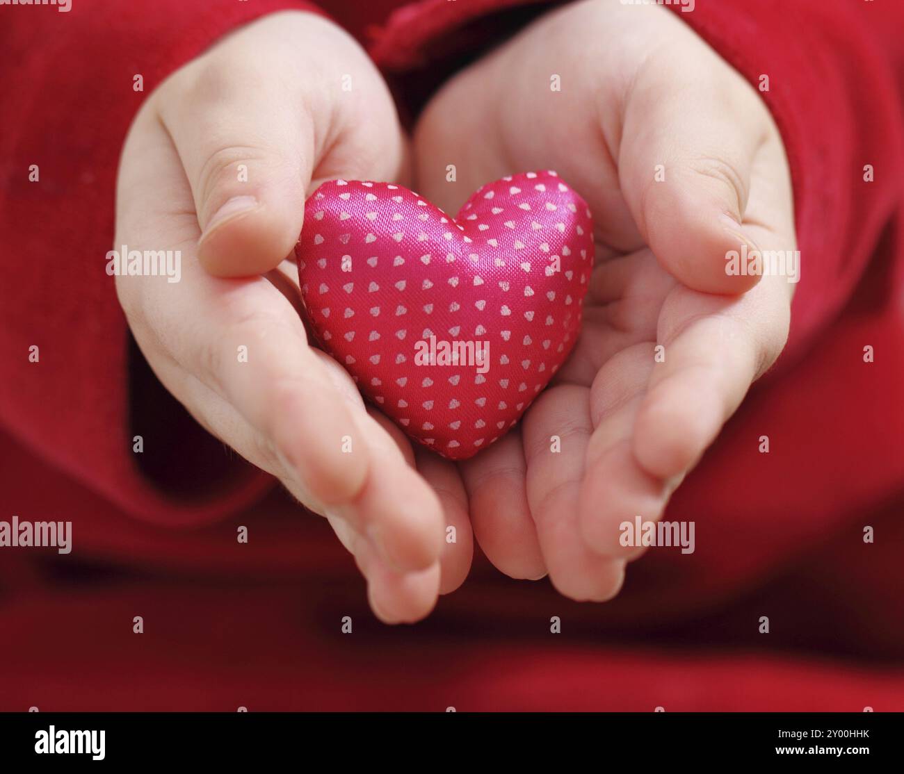 Child's hands hold heart from a pink satin with pattern Stock Photo - Alamy