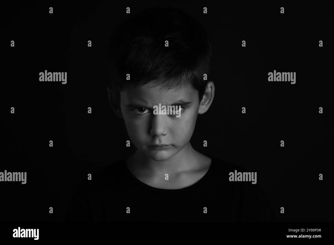 Angry little boy on dark background. Black and white effect Stock Photo ...