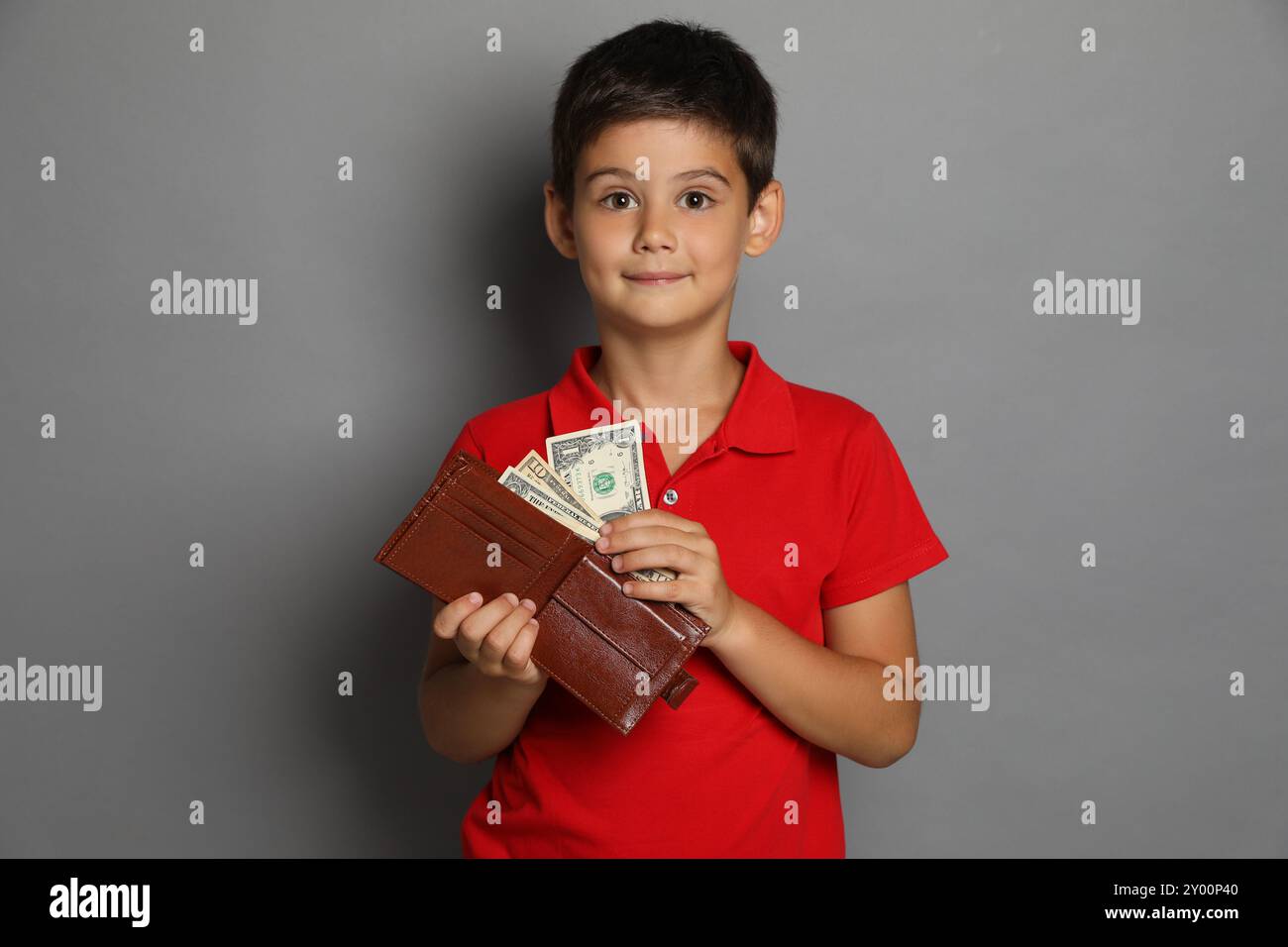Cute boy with wallet and pocket money on grey background Stock Photo ...