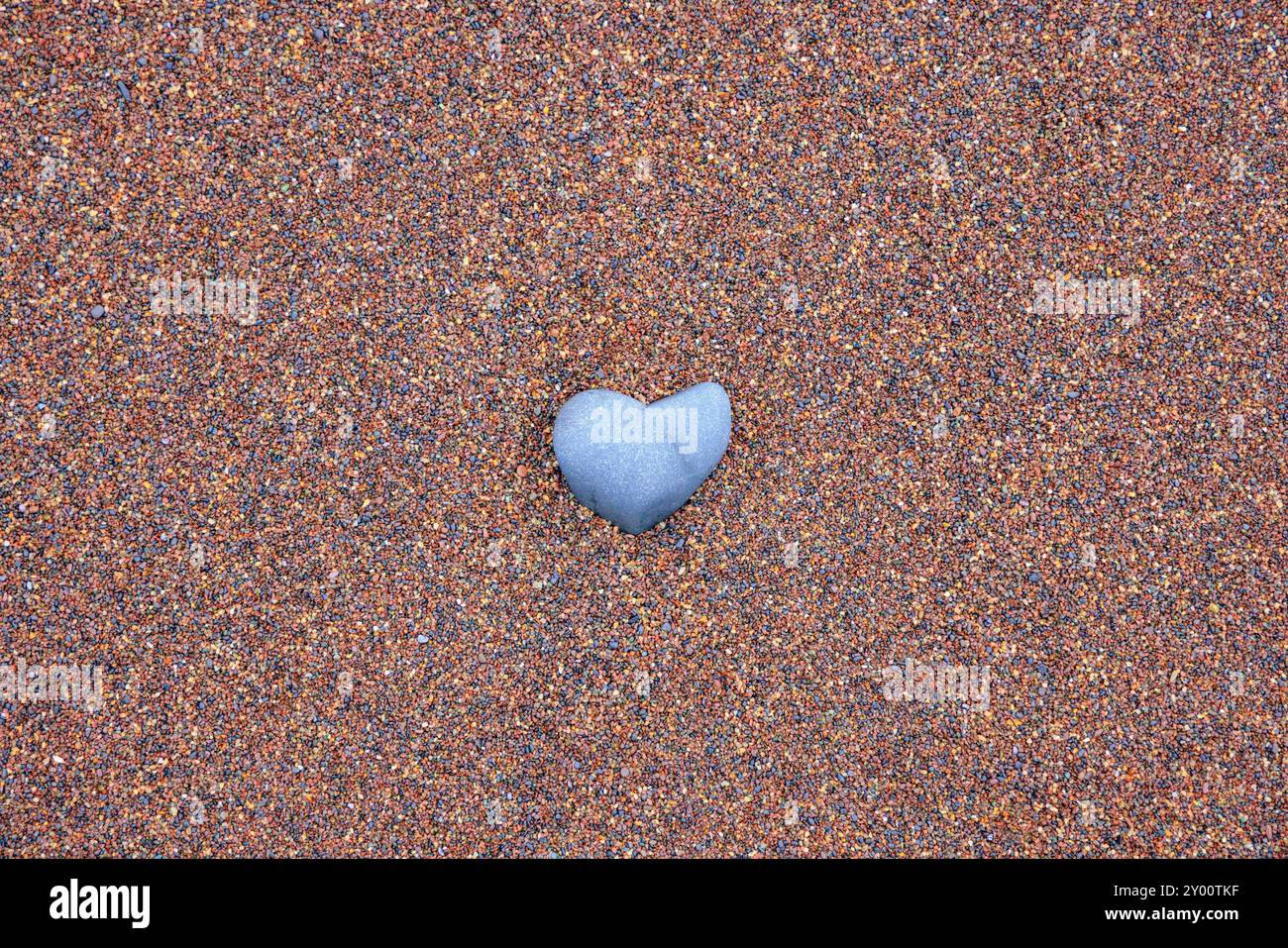 Heart shaped stone on sand background Stock Photo - Alamy