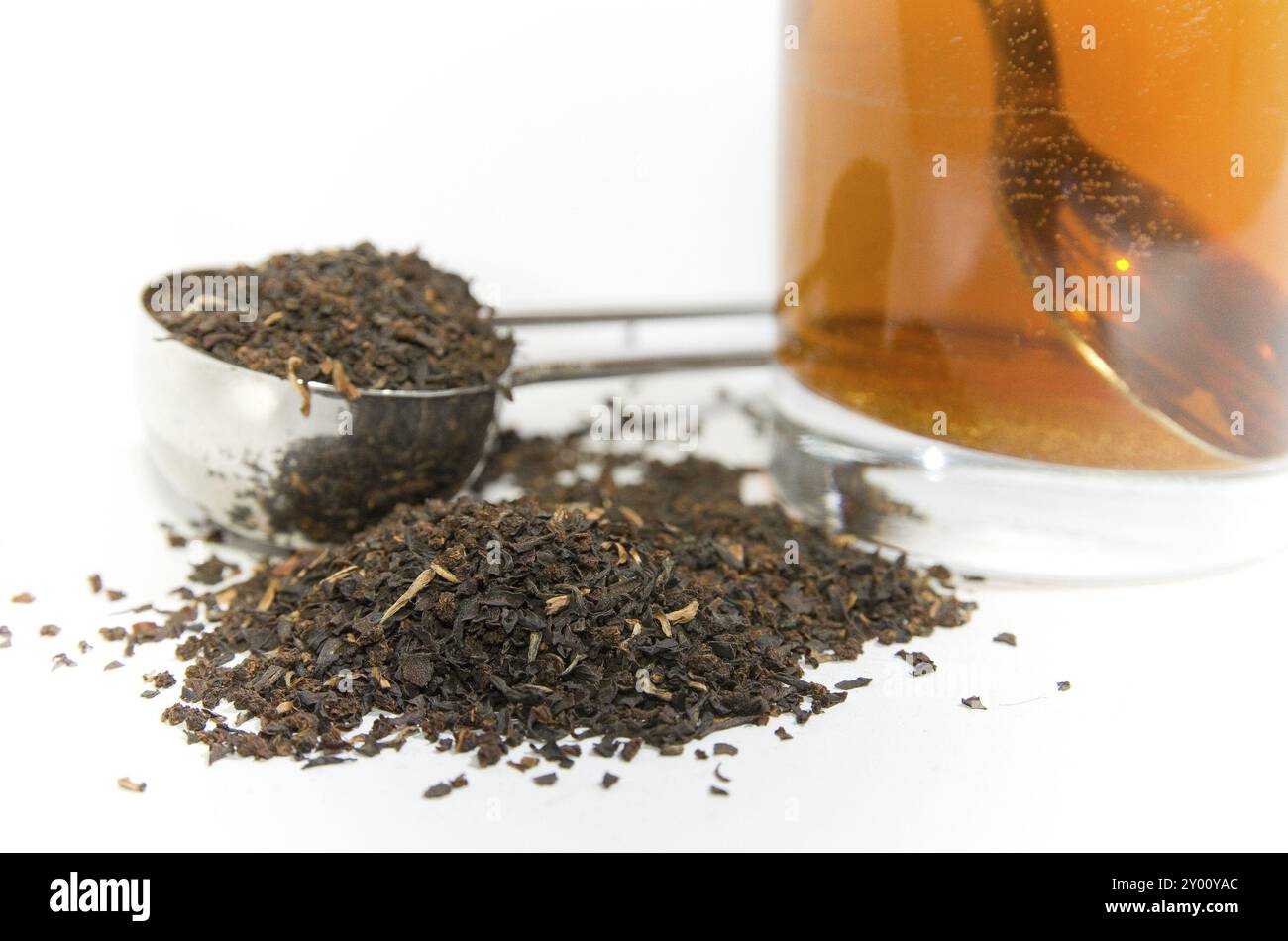 Tea leaves in measuring jug and a glass of tea. Tealeaves in measuring ...