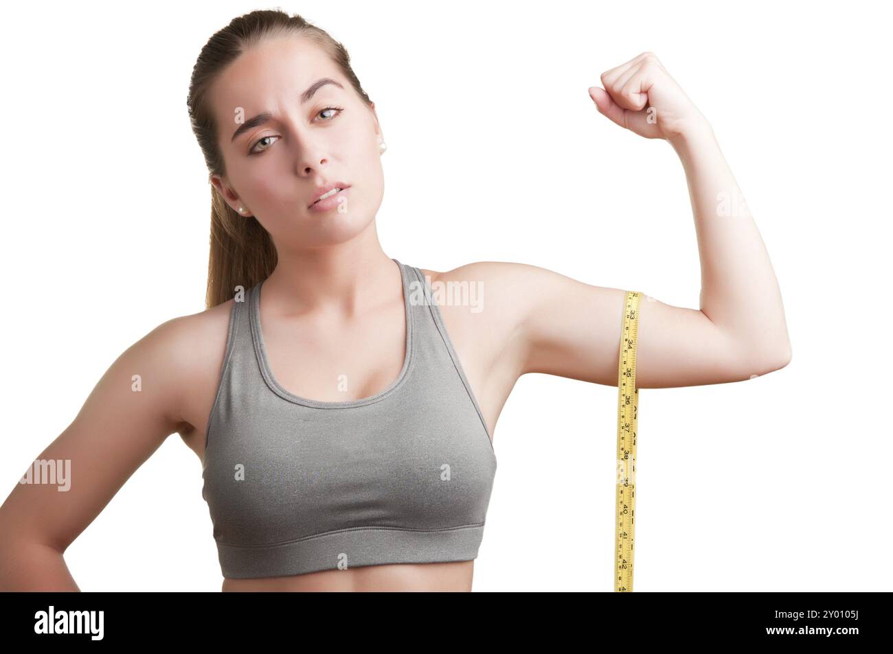 Powerful woman measuring her biceps with a yellow measuring tape Stock ...