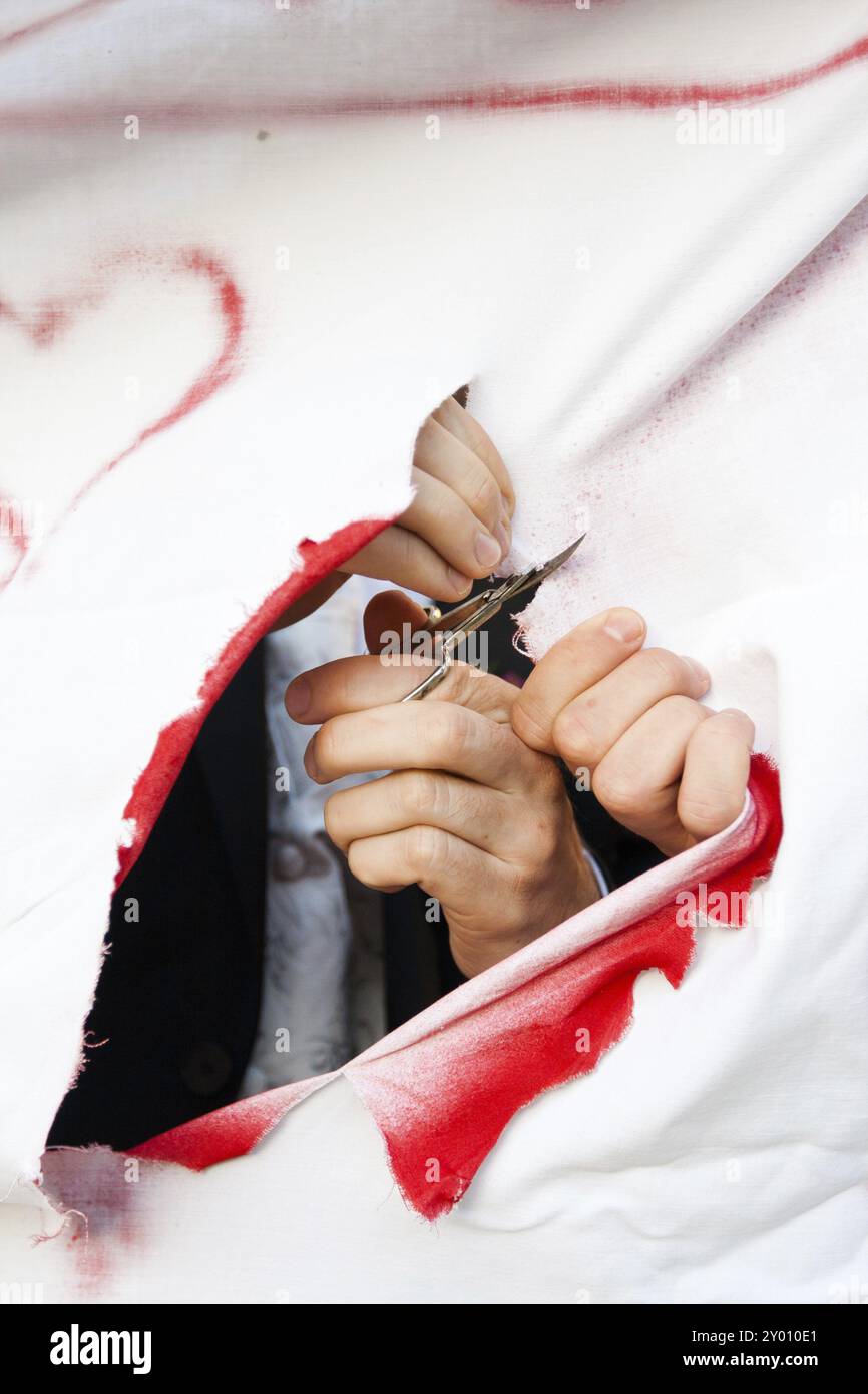 Bride and groom cut out a heart from a white bed sheet Stock Photo - Alamy