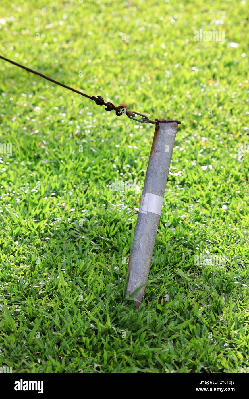 Rusty metal pole or iron stake is buried in the ground and firmly fixed ...