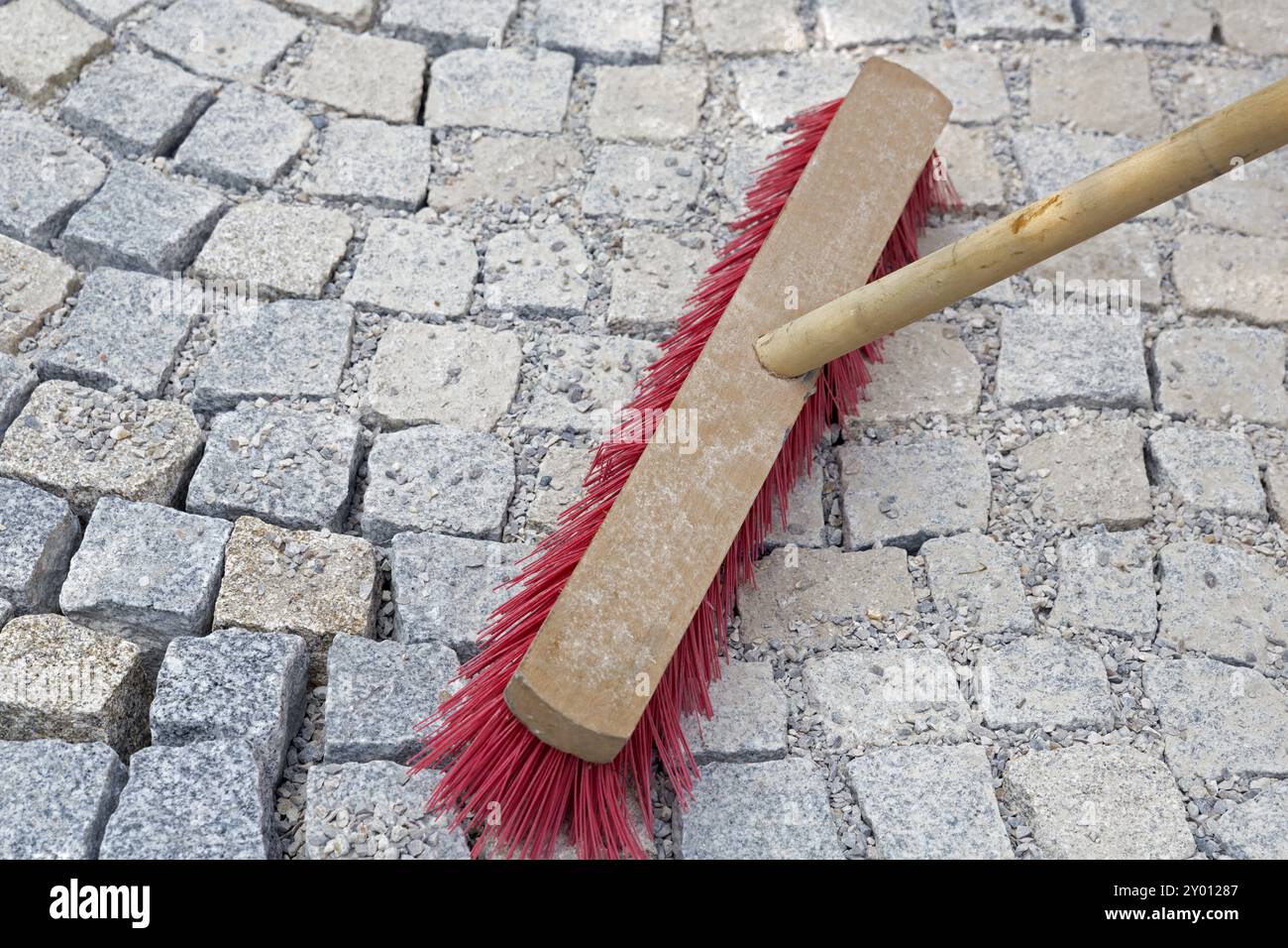 Sweep off freshly laid granite stones Stock Photo - Alamy