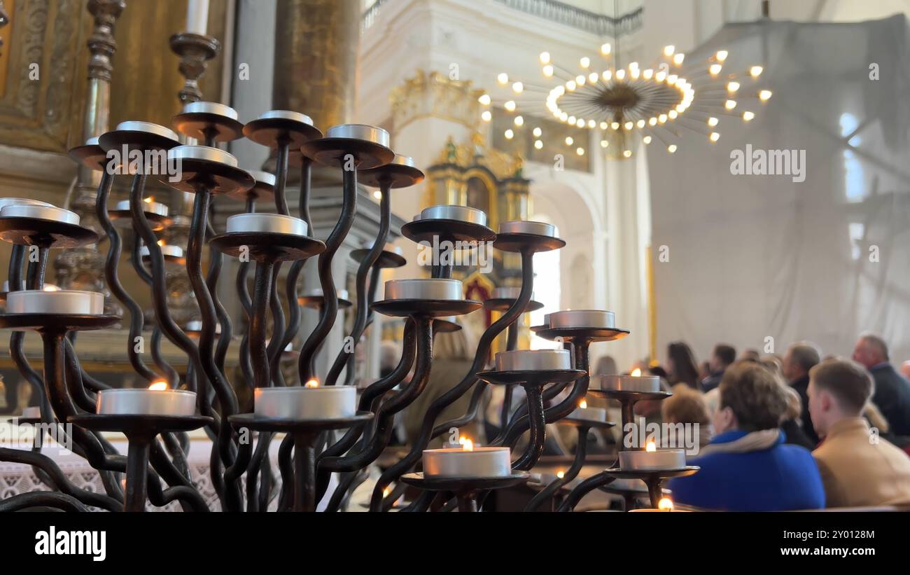 Burning candles in a Catholic church during the Divine Service Stock ...