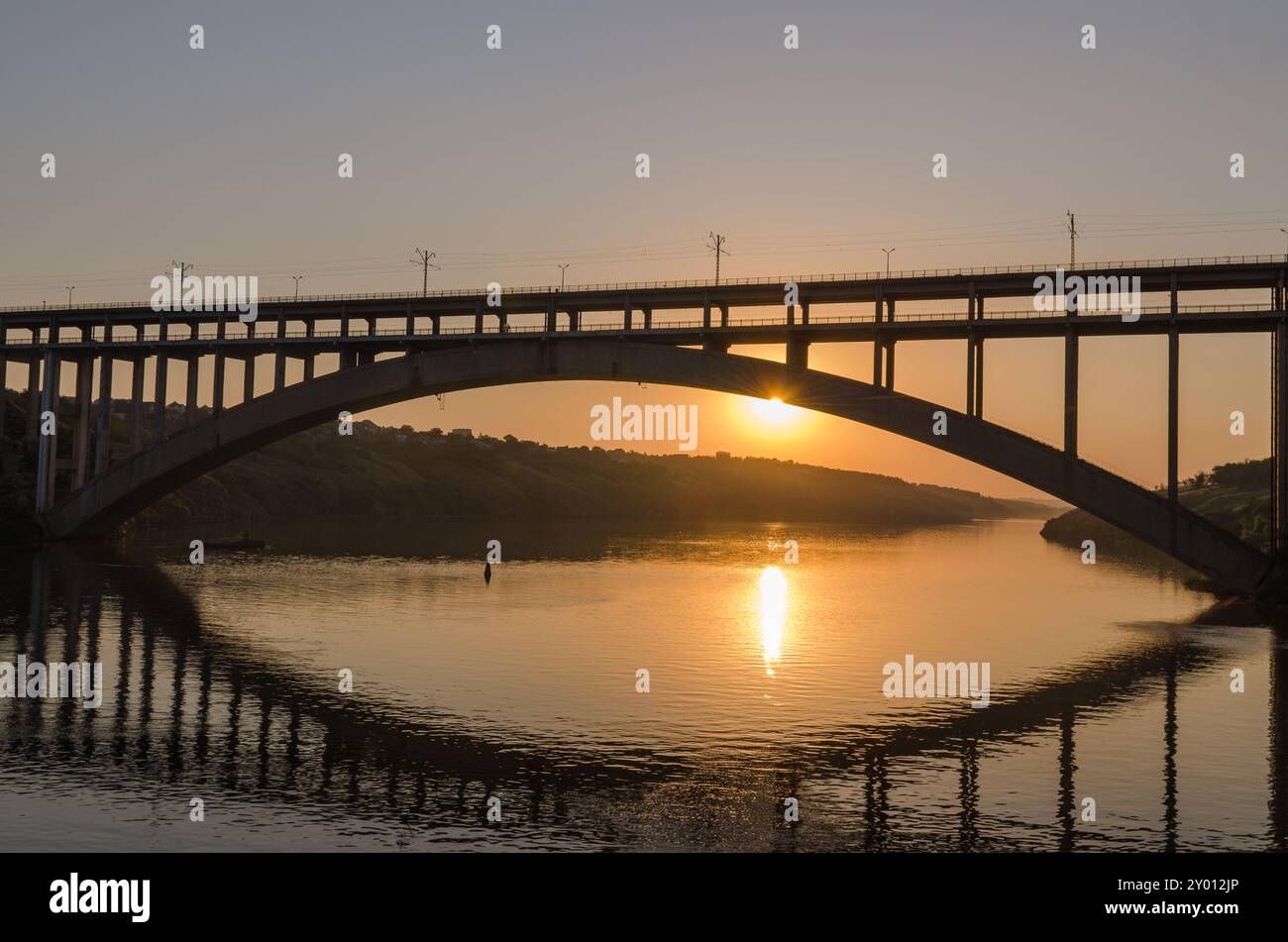 road and rail split-level bridge over the river on a background of blue ...
