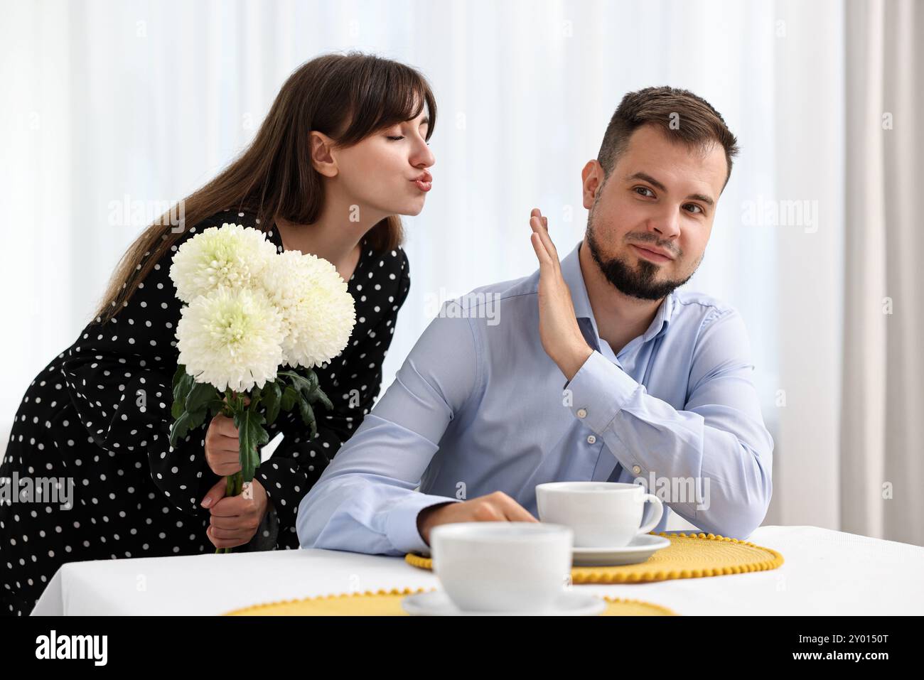 Bad date. Embarrassed man refusing from woman's kiss indoors Stock ...