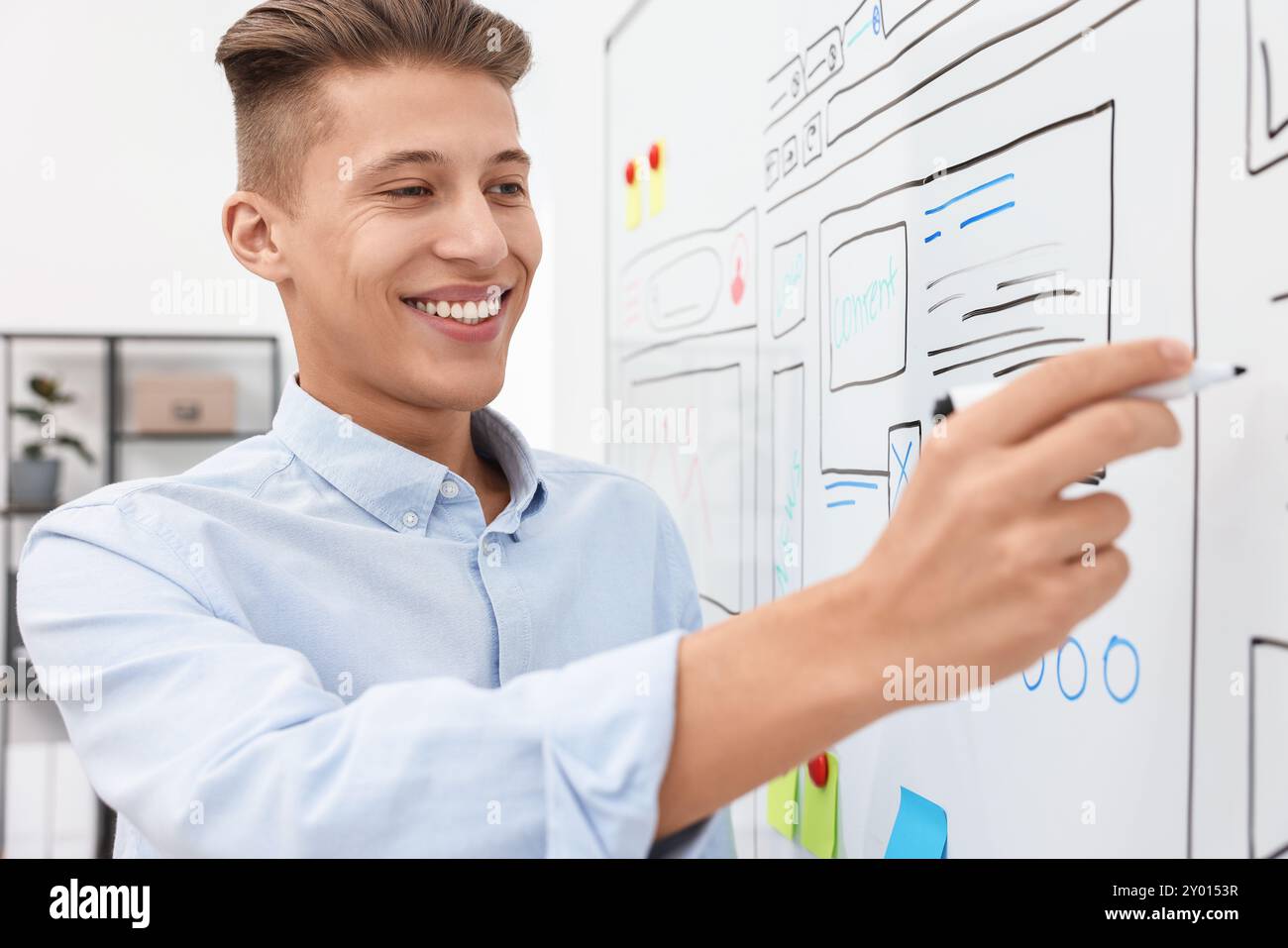 Developing UI design. Man drawing website wireframe on whiteboard ...