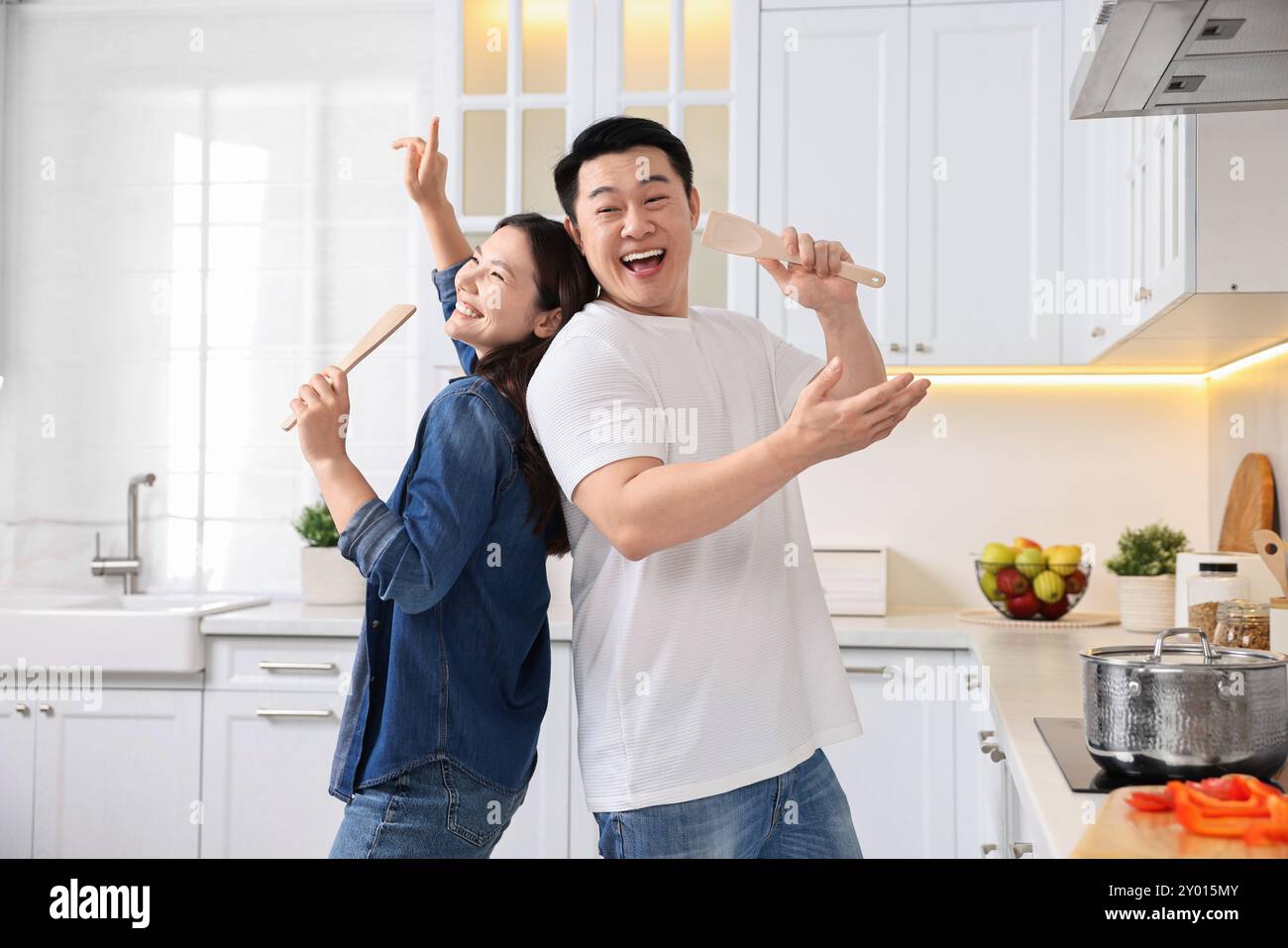 Happy lovely couple singing together while cooking in kitchen Stock ...
