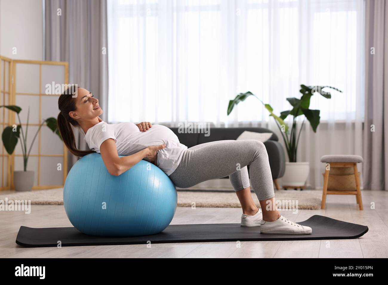 Beautiful pregnant woman doing exercises on fitball at home Stock Photo ...