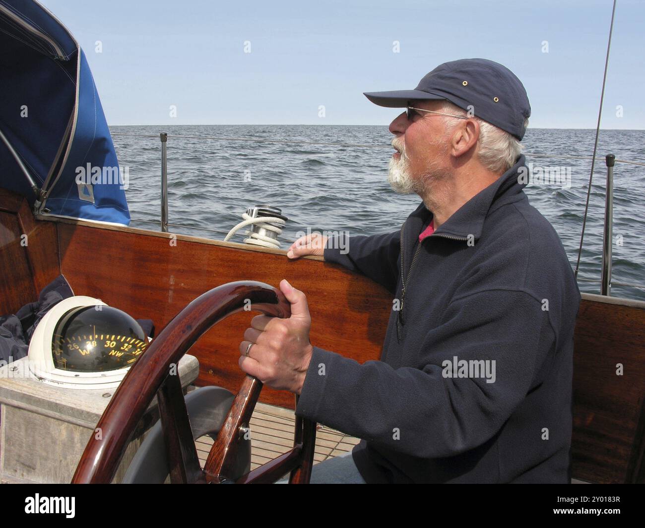 Skipper sits at the helm on a sailing yacht Stock Photo - Alamy