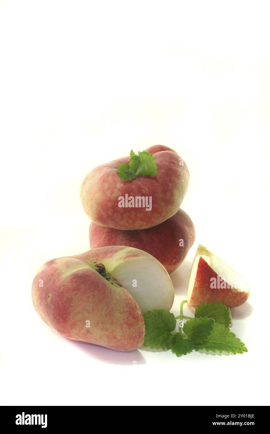 Fresh cut mountain peaches with lemon balm against a white background ...