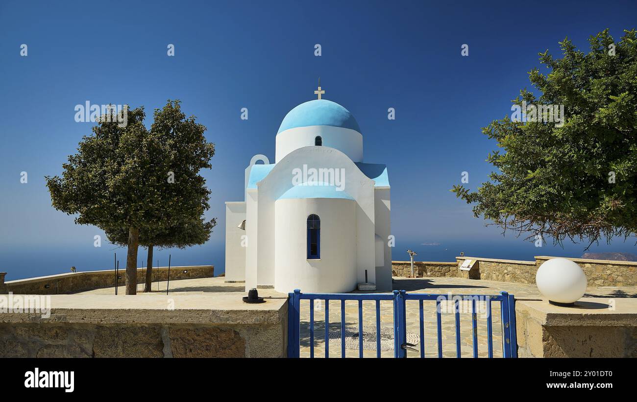 White-blue church behind a lattice gate with surrounding trees under a ...