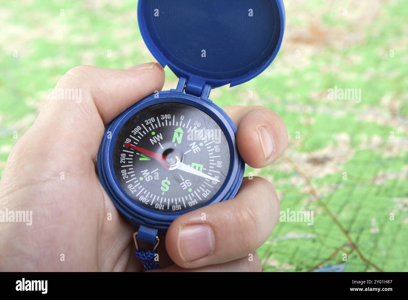 Hand holding travel north direction compass on map Stock Photo - Alamy