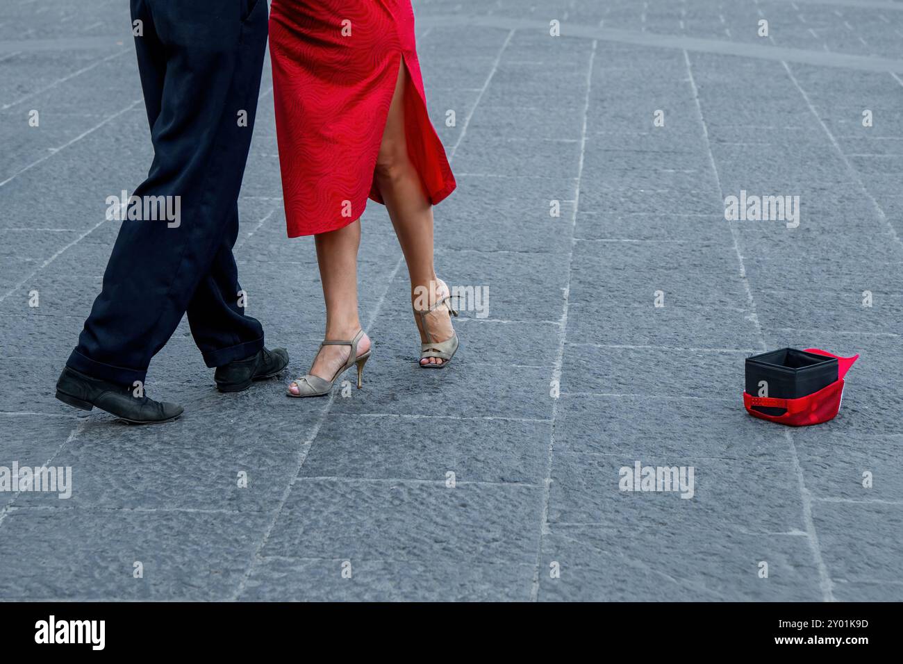 Close-up of street performers' feet dancing tango on city pavement ...