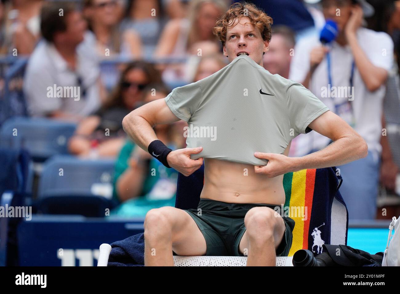 Jannik Sinner, of Italy, changes his shirt during a break between games ...