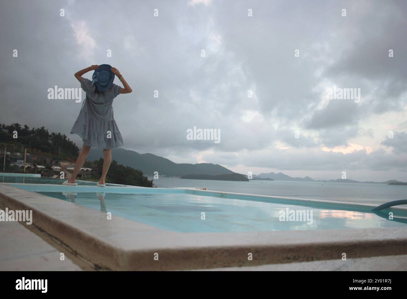 Dolsan-eup, Yeosu-si, South Korea - July 26, 2024: Young woman watching ...