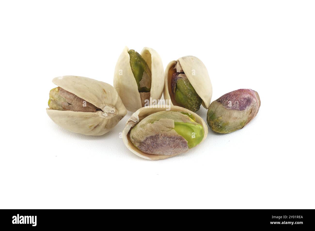 Pistachios in-shell and others peeled exposing the green nuts inside ...