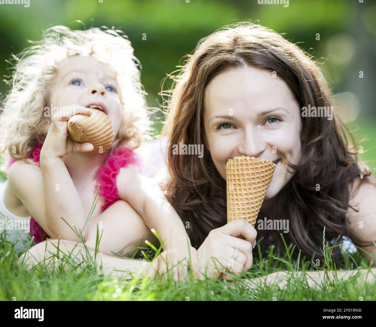 Happy family eating ice-cream outdoors in spring park against blurred ...