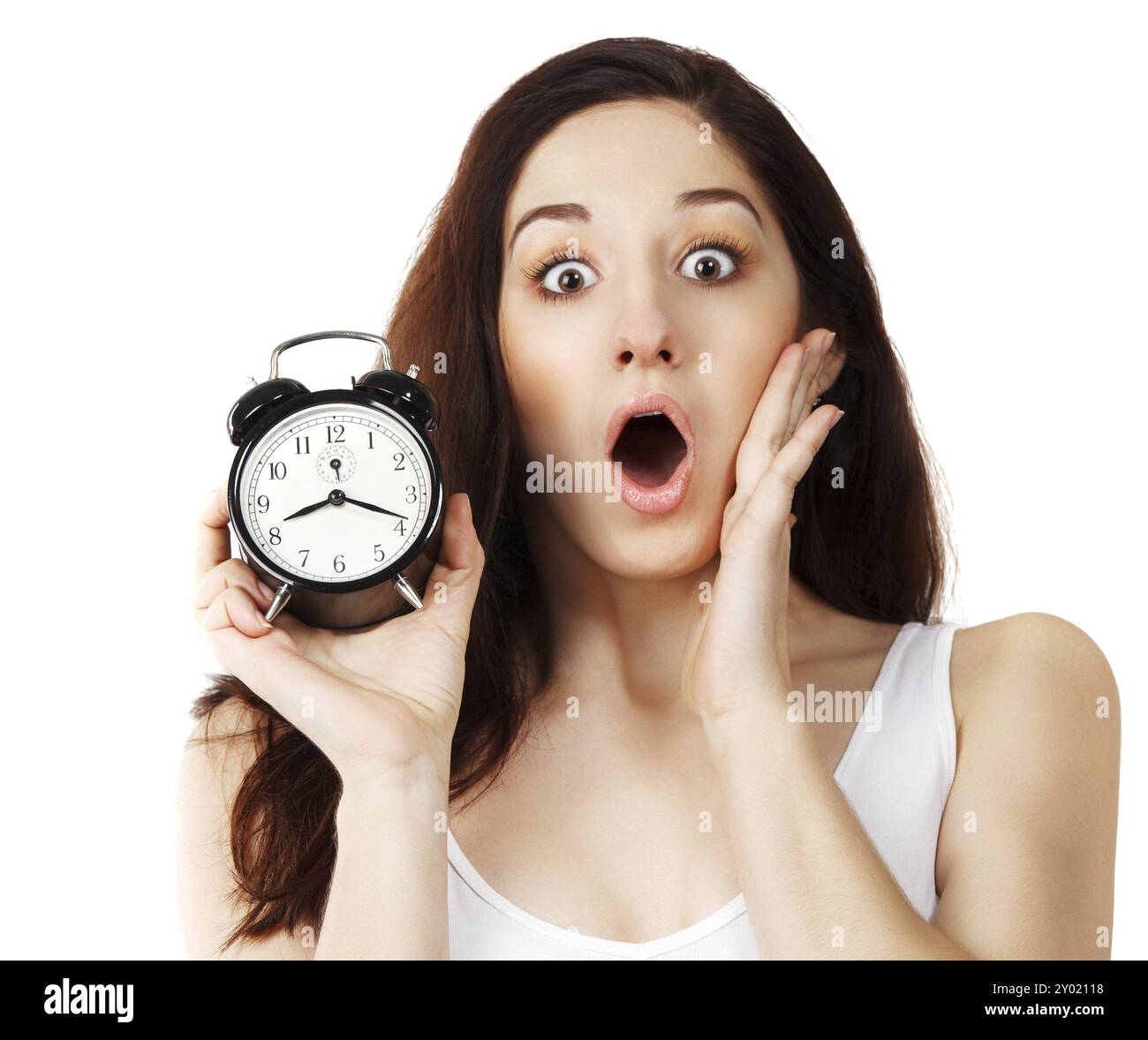 Surprised young brunette woman holding clock in her hand in amazement ...
