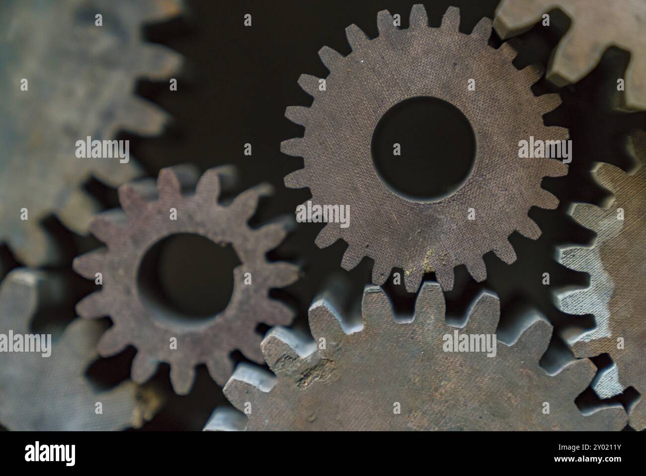 Interlocking gear wheels in front of a black wall Stock Photo - Alamy