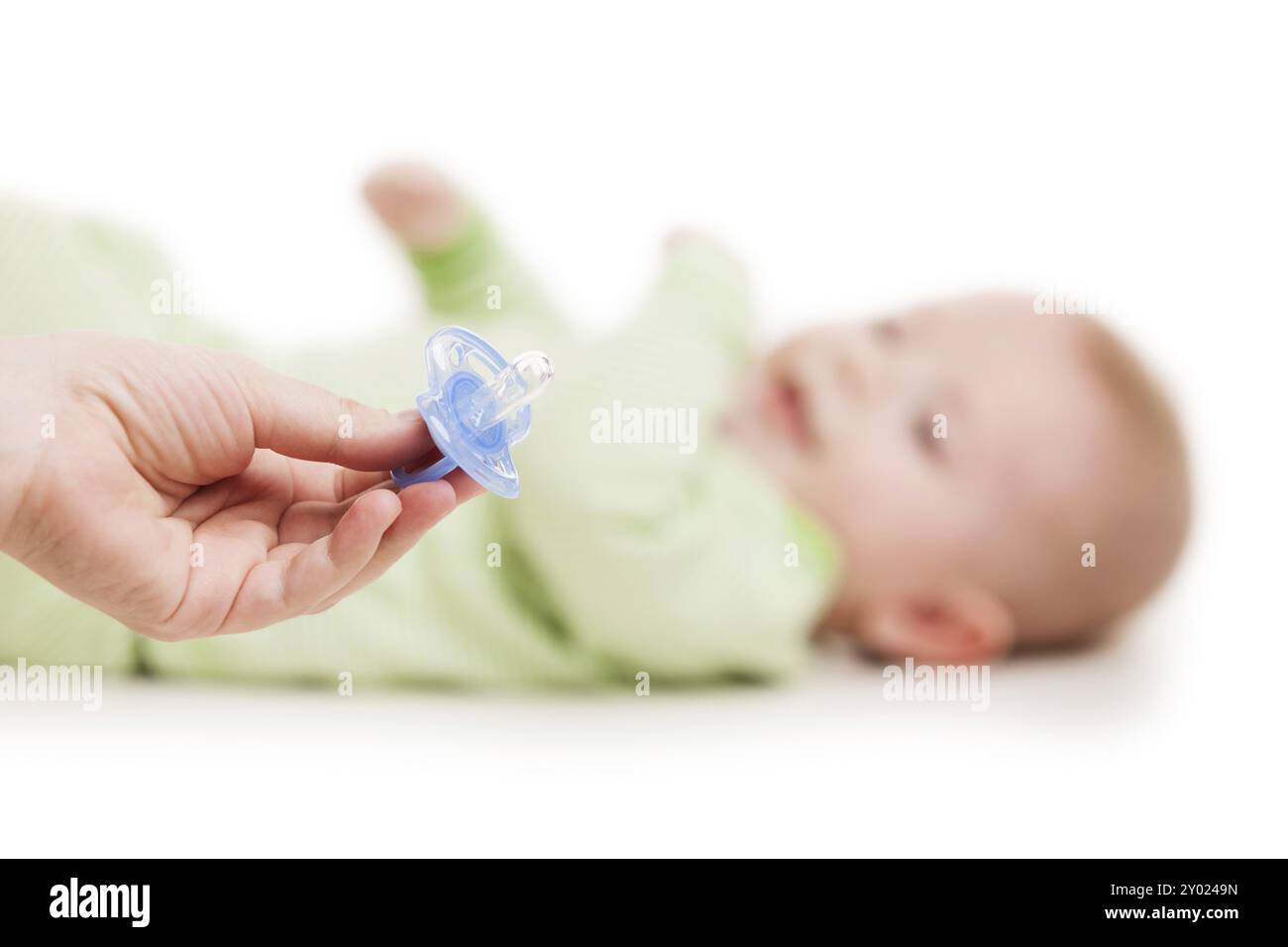 Mother hand giving plastic soother pacifier to little cute sleeping ...