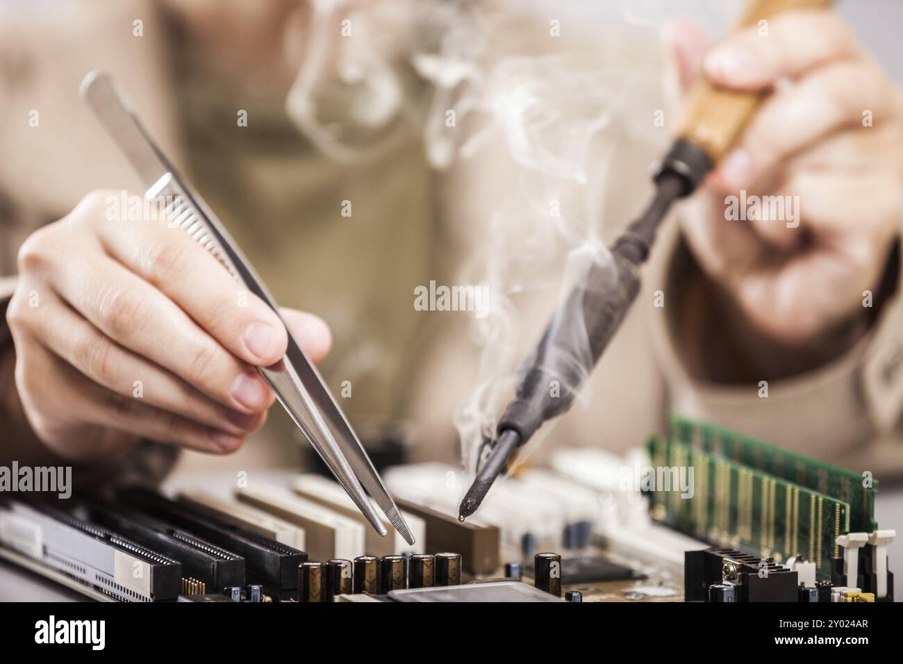 Manual worker human hand holding soldering iron tool repairing computer ...