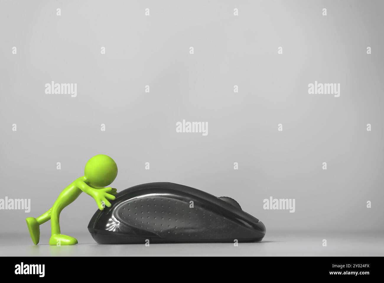 Green man pushing a computer mouse. Gray background Stock Photo - Alamy