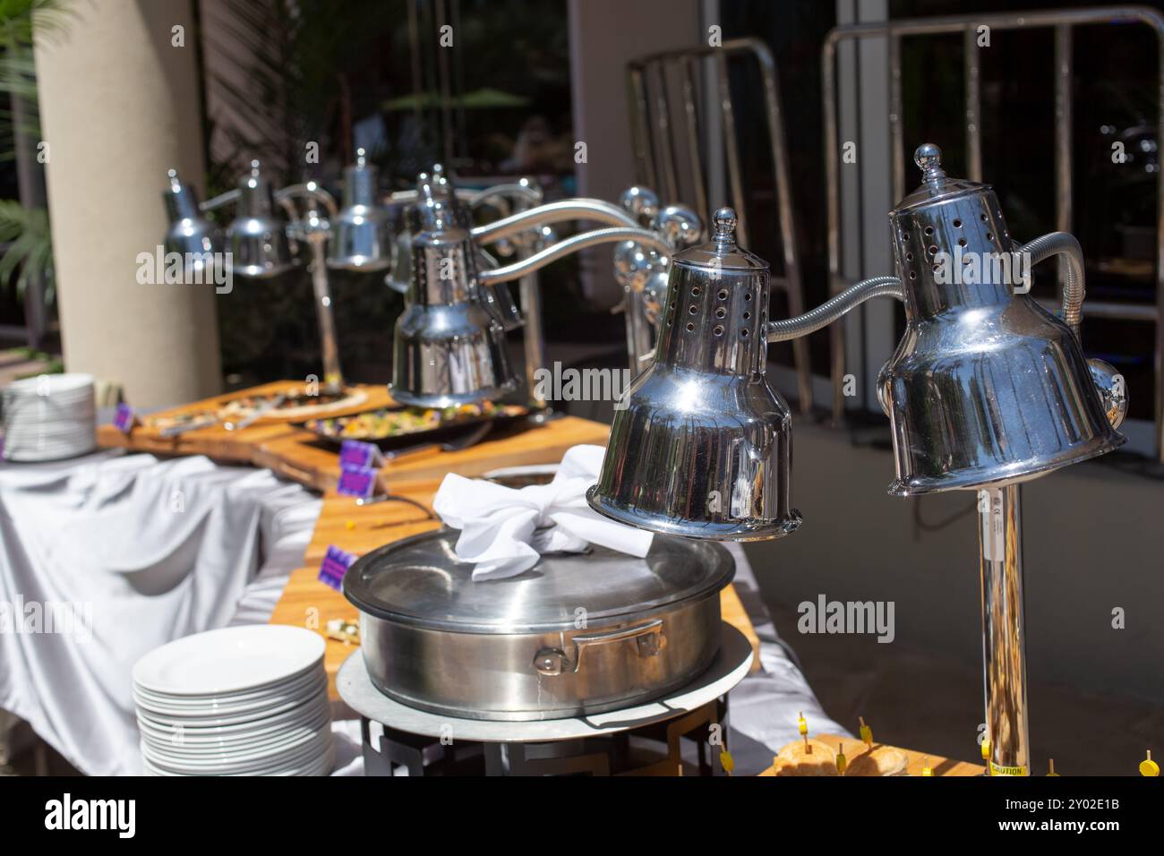A view of a table full of food platters, featuring heat lamps, in an ...