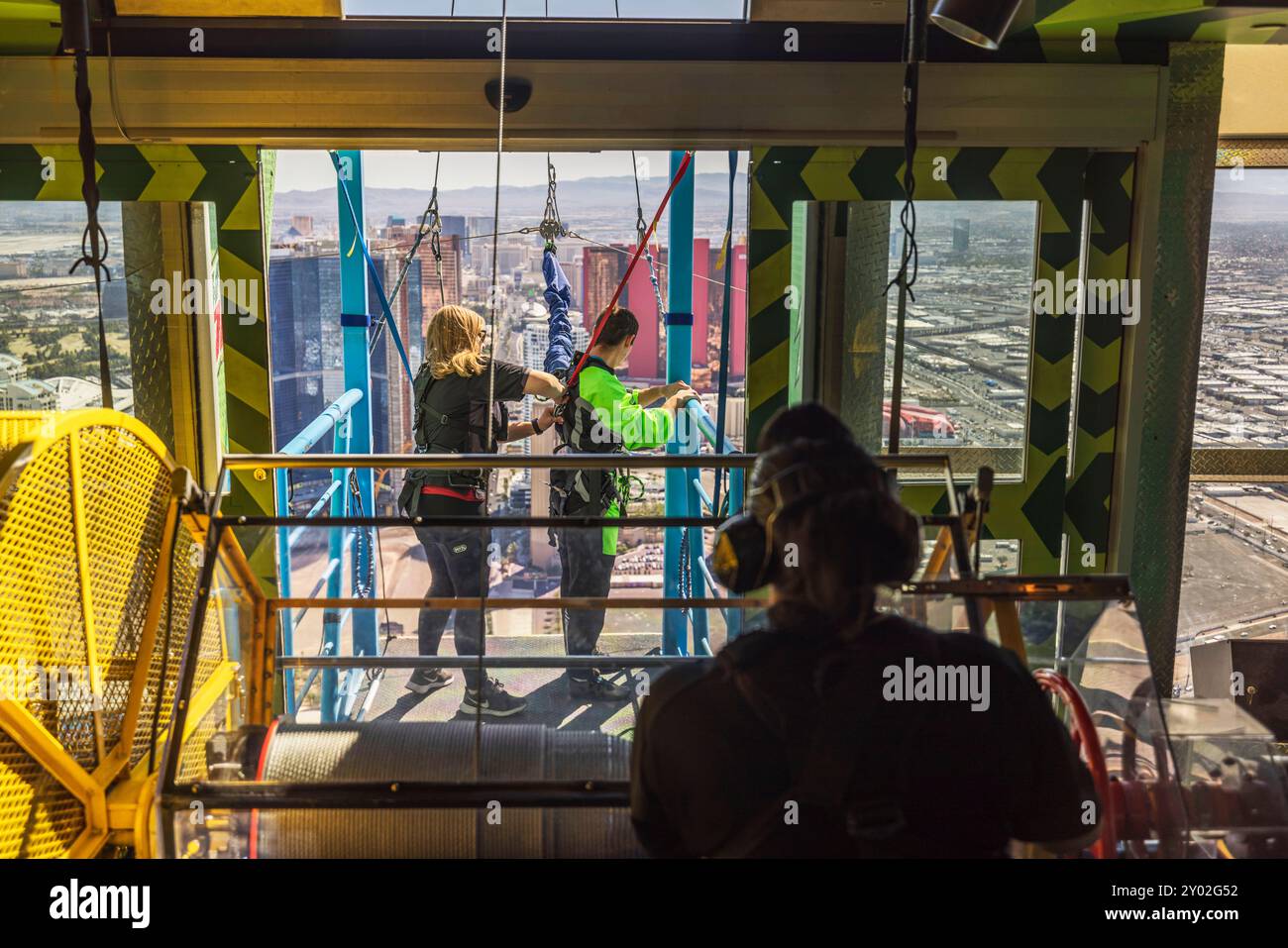 Instructor checks the harness of person preparing to bungee jump from ...