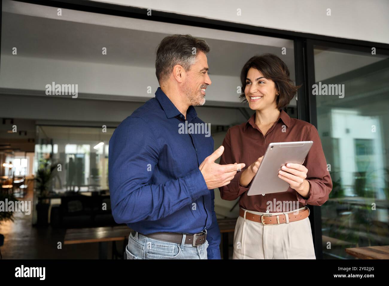 Two happy business colleagues having conversation at office meeting ...