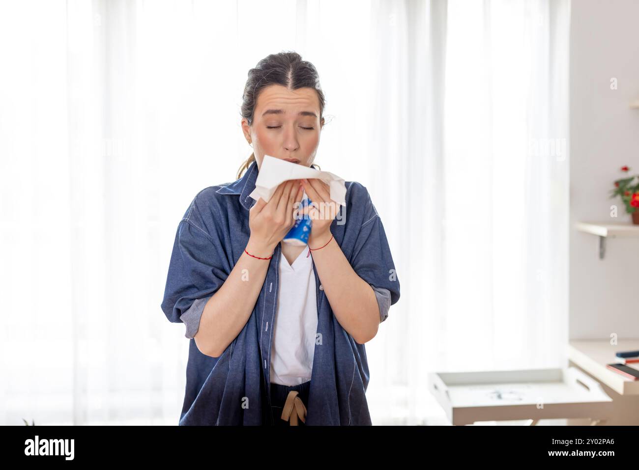 Close up sick young woman blowing running nose, sneezing, holding paper ...