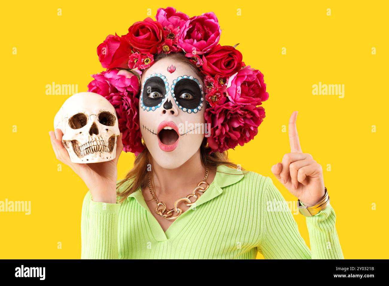 Shocked young woman with painted skull on yellow background. Mexico's ...