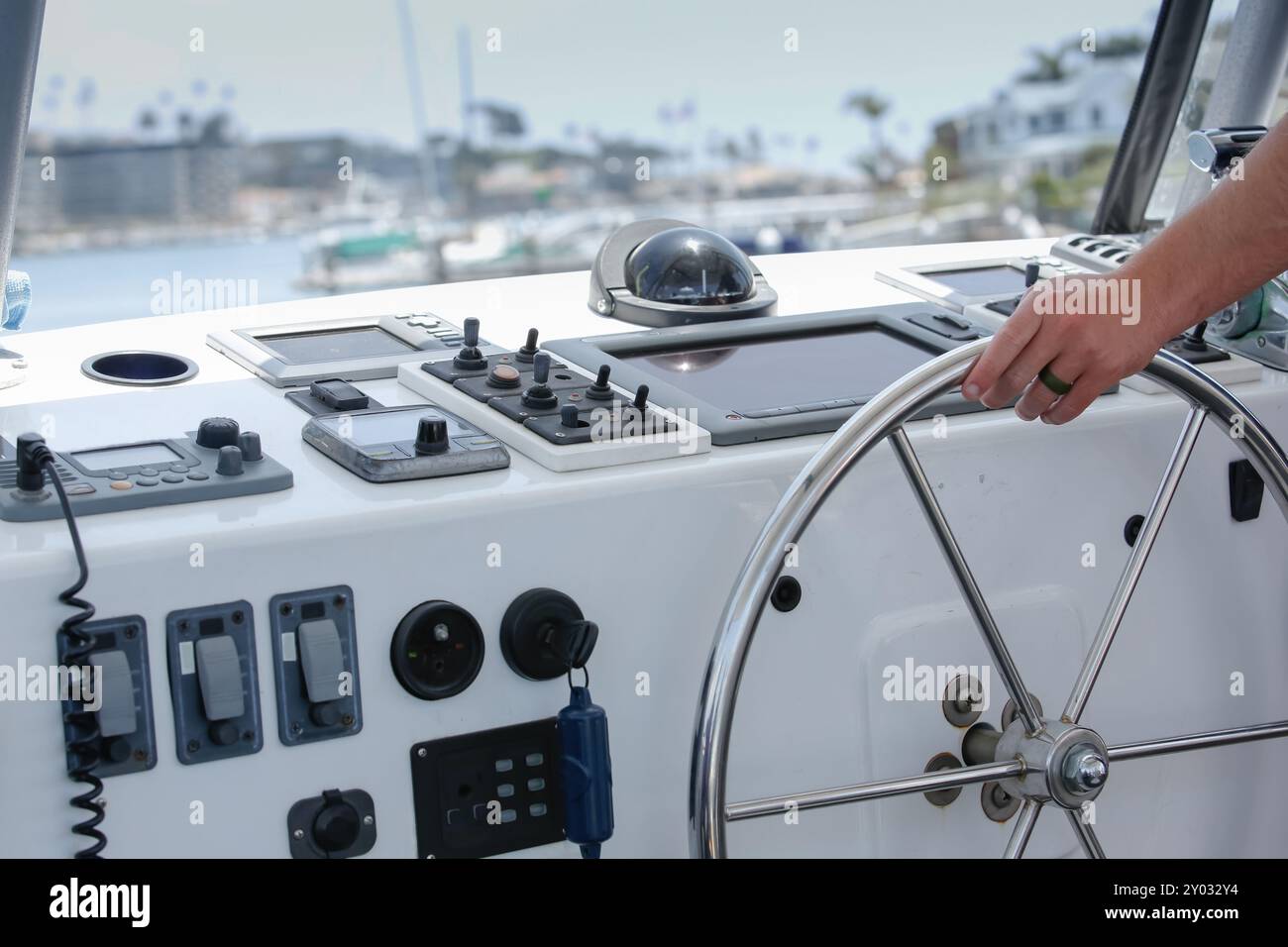 A view of the captain's hand using the steering wheel in the helm of a ...