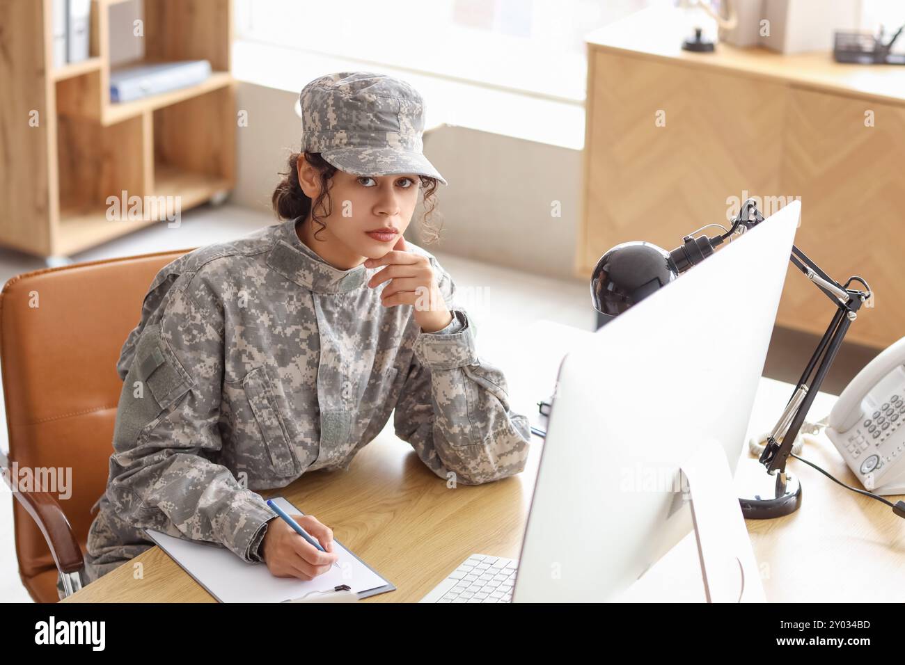 Female African-American soldier working at table in headquarters Stock ...