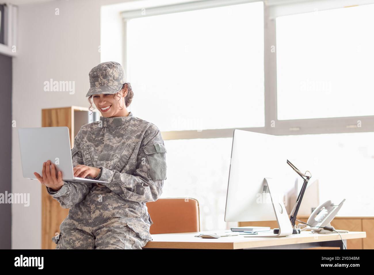 Female African-American soldier working with laptop at headquarters ...